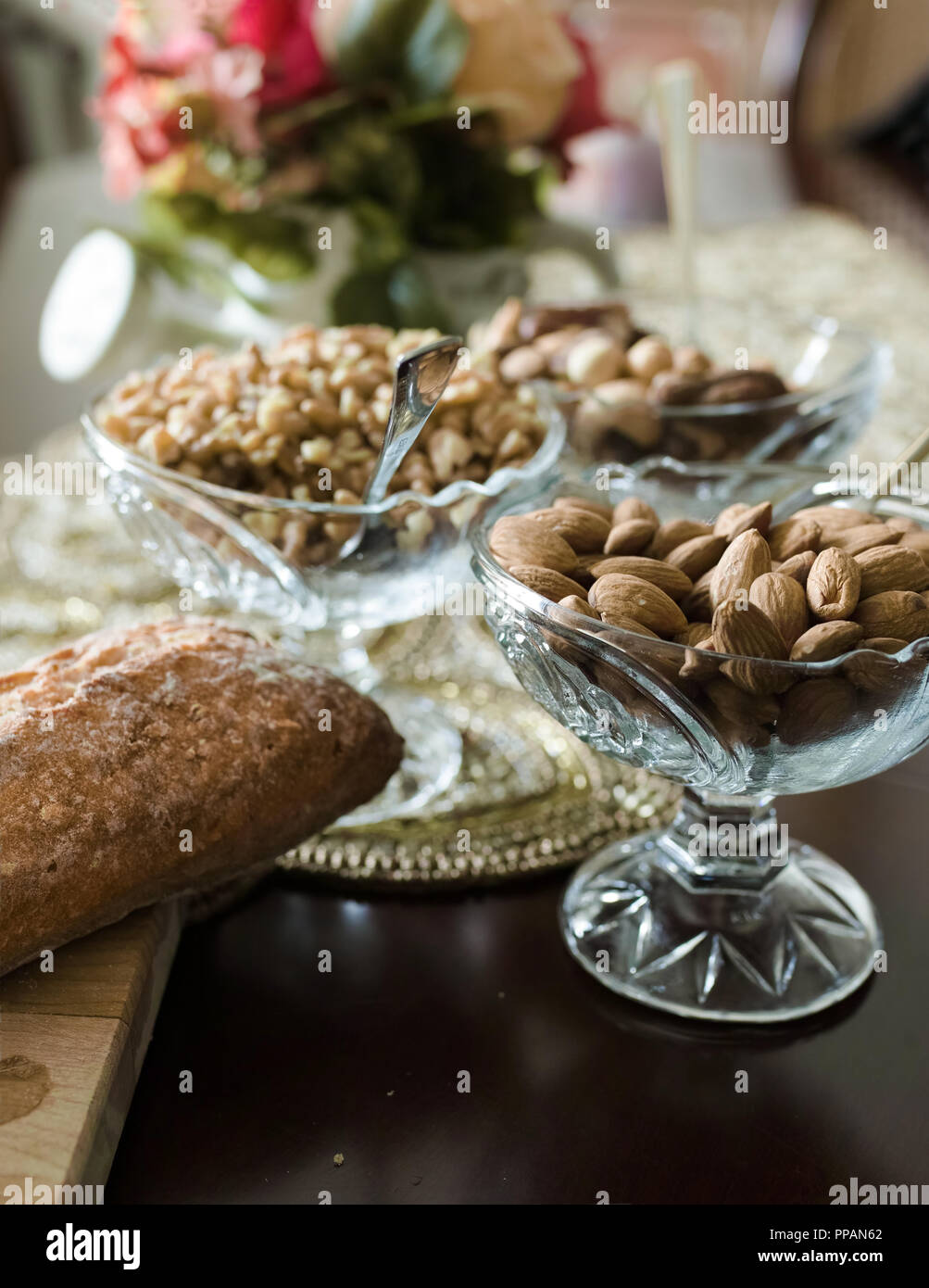 A cauldron, rustic bread on the breadboard, cups with nuts, all on the ...