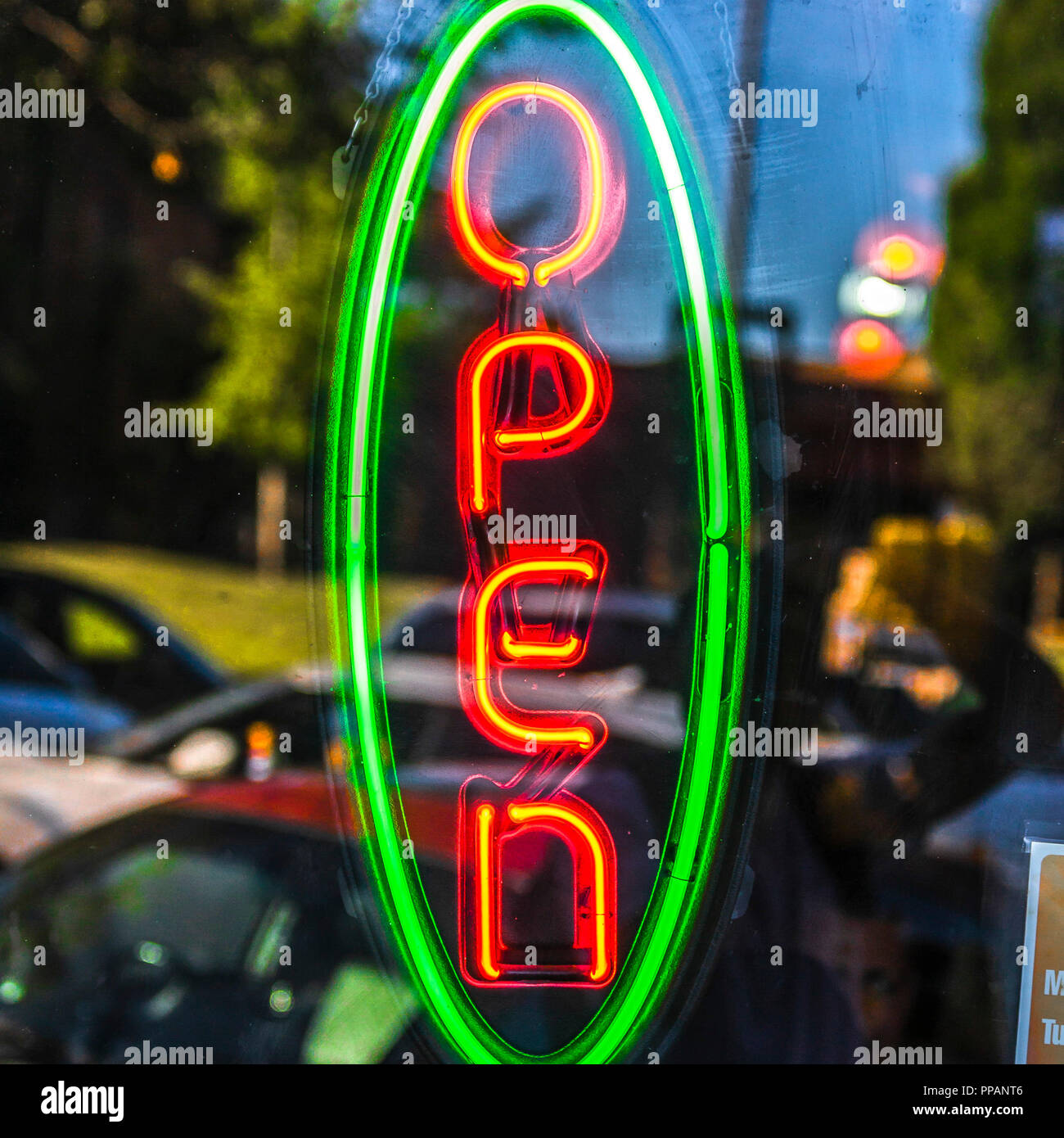 Neon Open sign on a glass door with reflections Stock Photo - Alamy