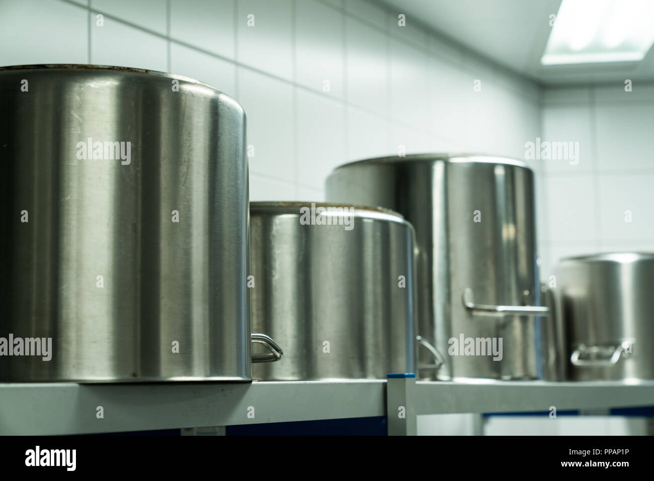row of large metal cooking pots in an industrial size restaurant ...