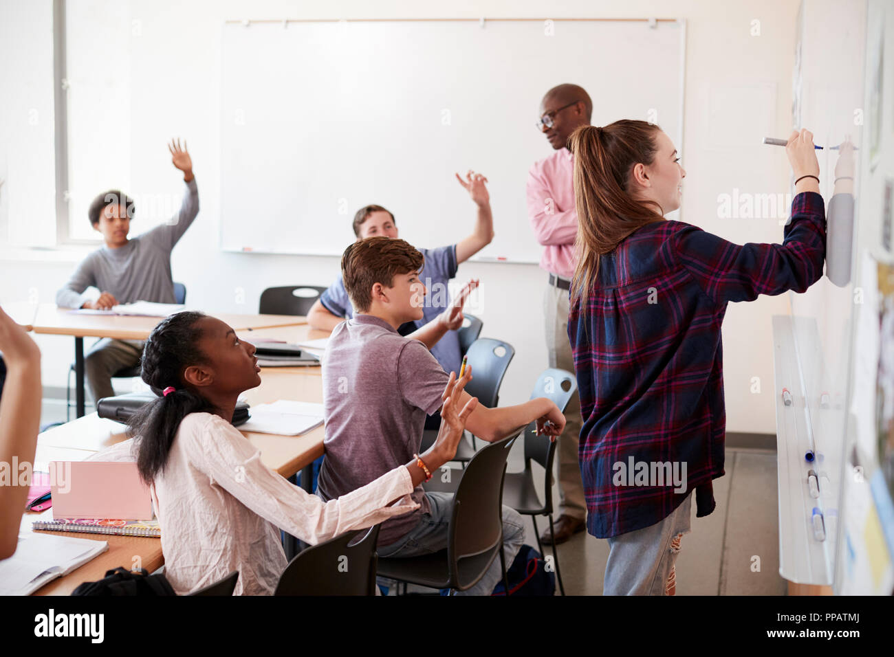 Female High School Pupil Writing On Whiteboard In Class Stock Photo - Alamy
