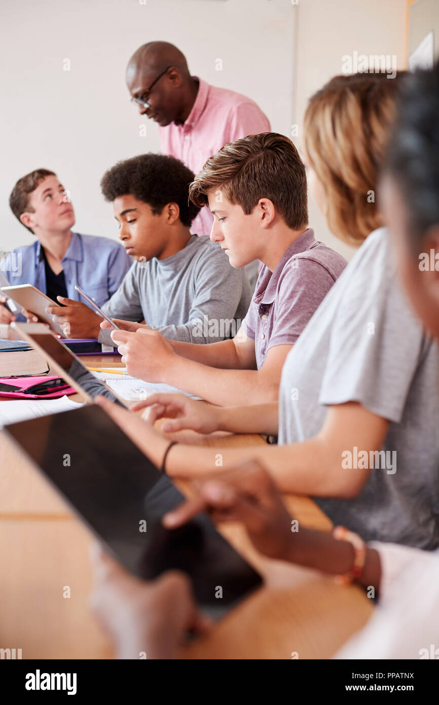 High School Teacher With Pupils Using Digital Tablets In Technology ...