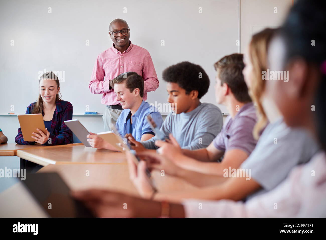 High School Teacher With Pupils Using Digital Tablets In Technology ...