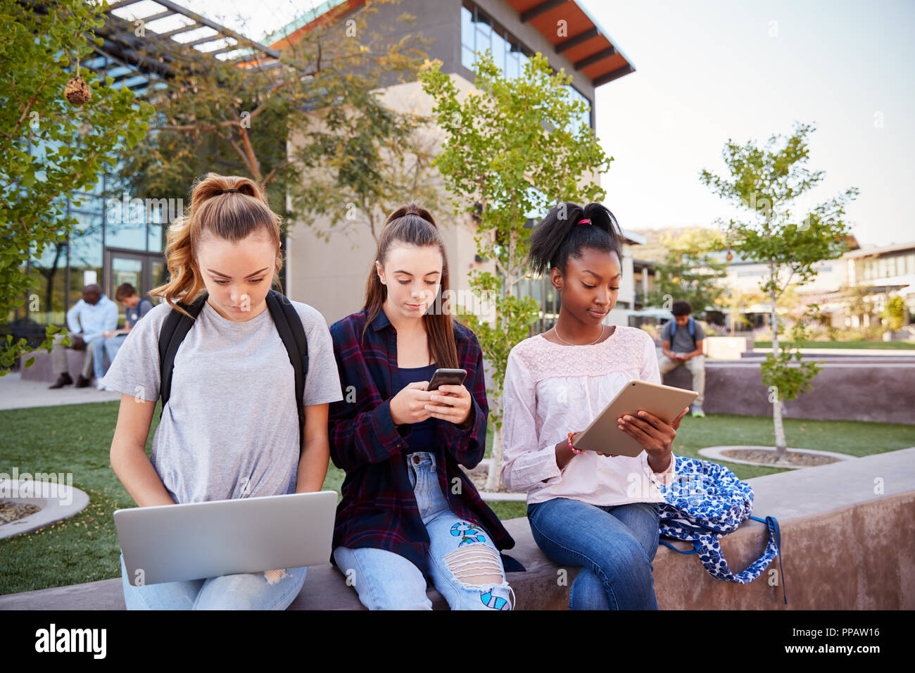 Female High School Students Using Digital Devices Outdoors During ...
