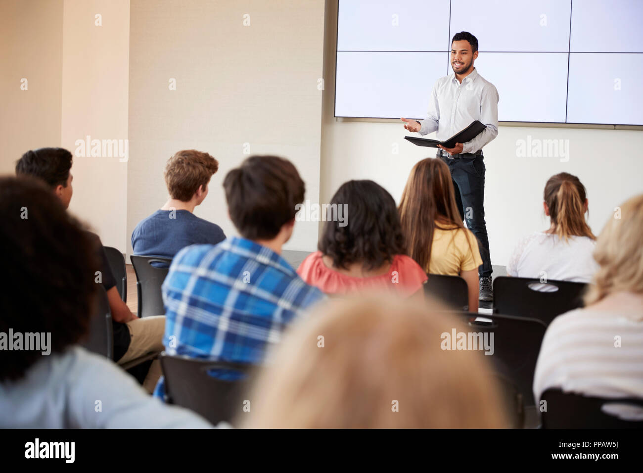 Teacher Giving Presentation To High School Class In Front Of Screen ...