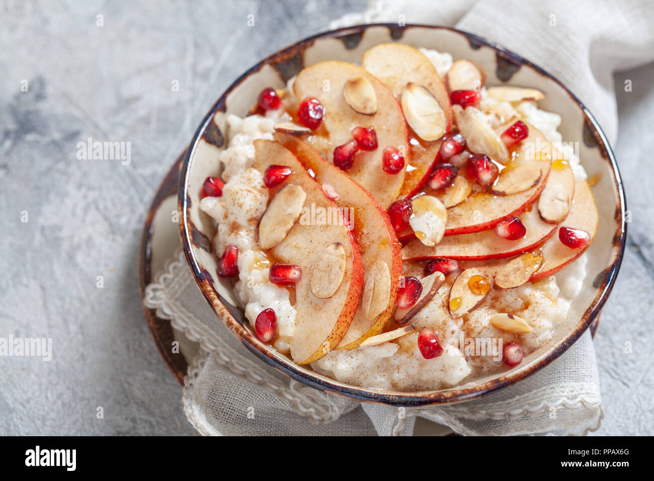 Coconut rice with pomegranate, pear and almond slices Stock Photo - Alamy