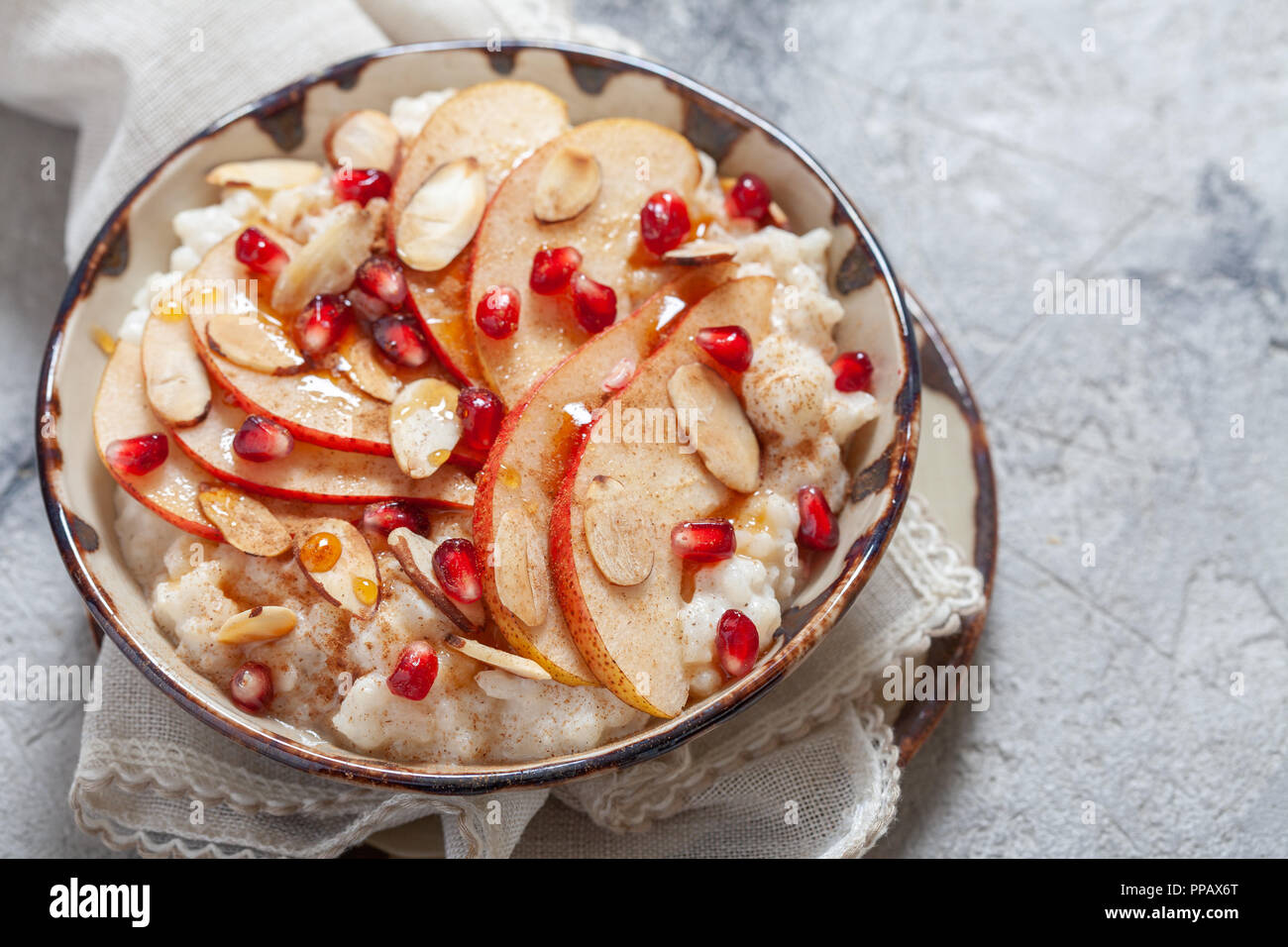 Coconut rice with pomegranate, pear and almond slices Stock Photo - Alamy