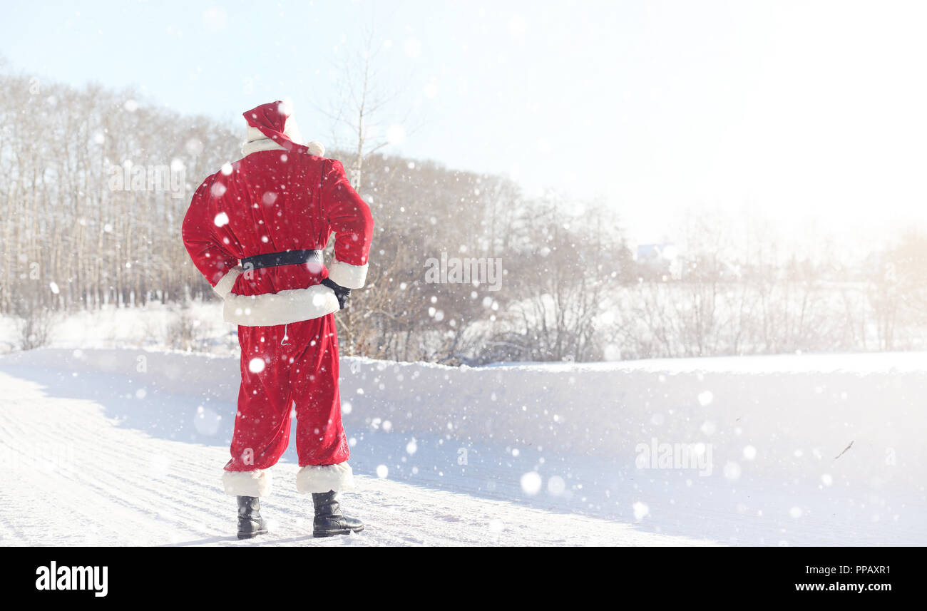Santa Claus comes with gifts from the outdoor. Santa in a red su Stock ...