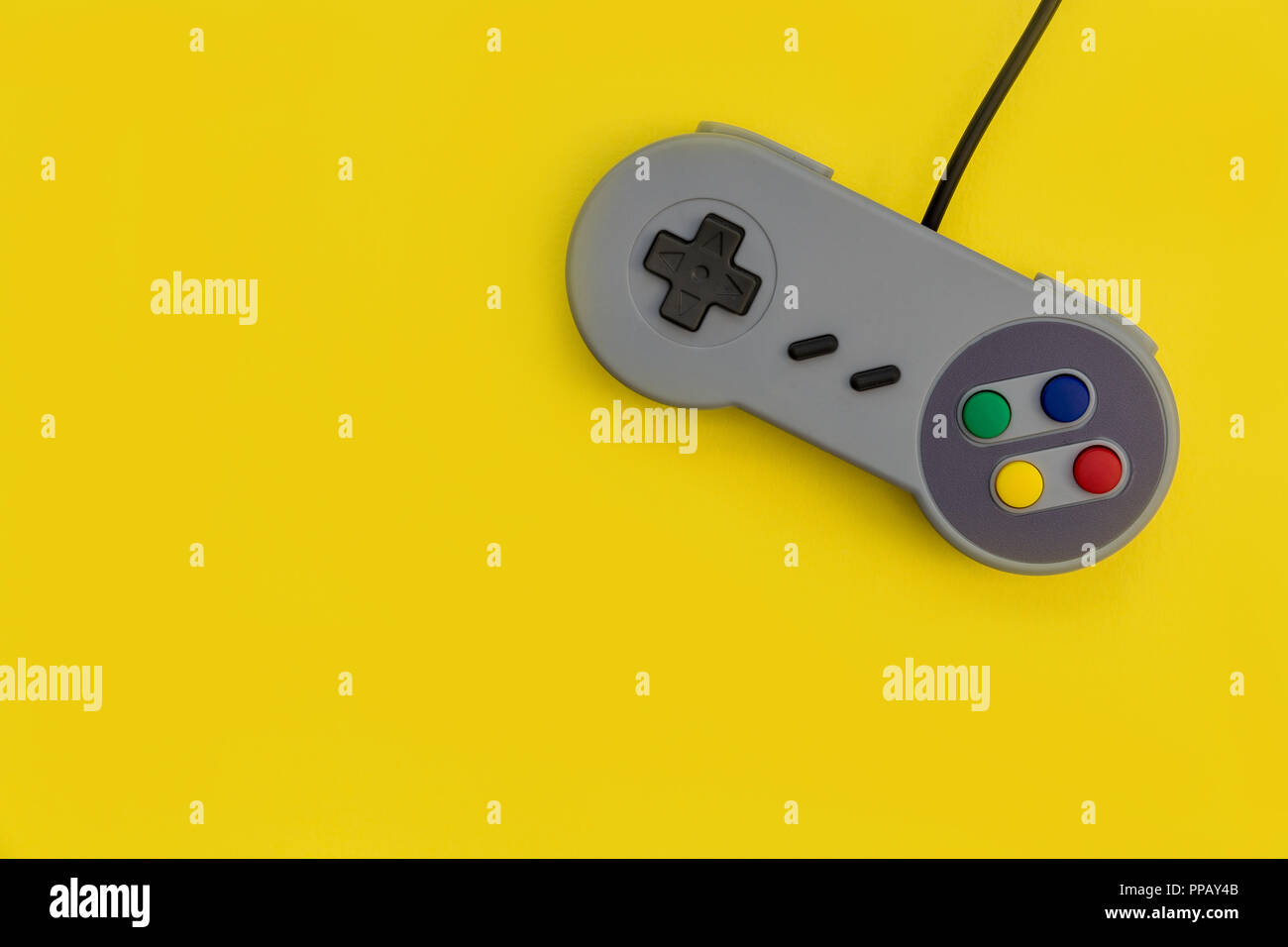 Retro video game controller on yellow background copy space Stock Photo ...