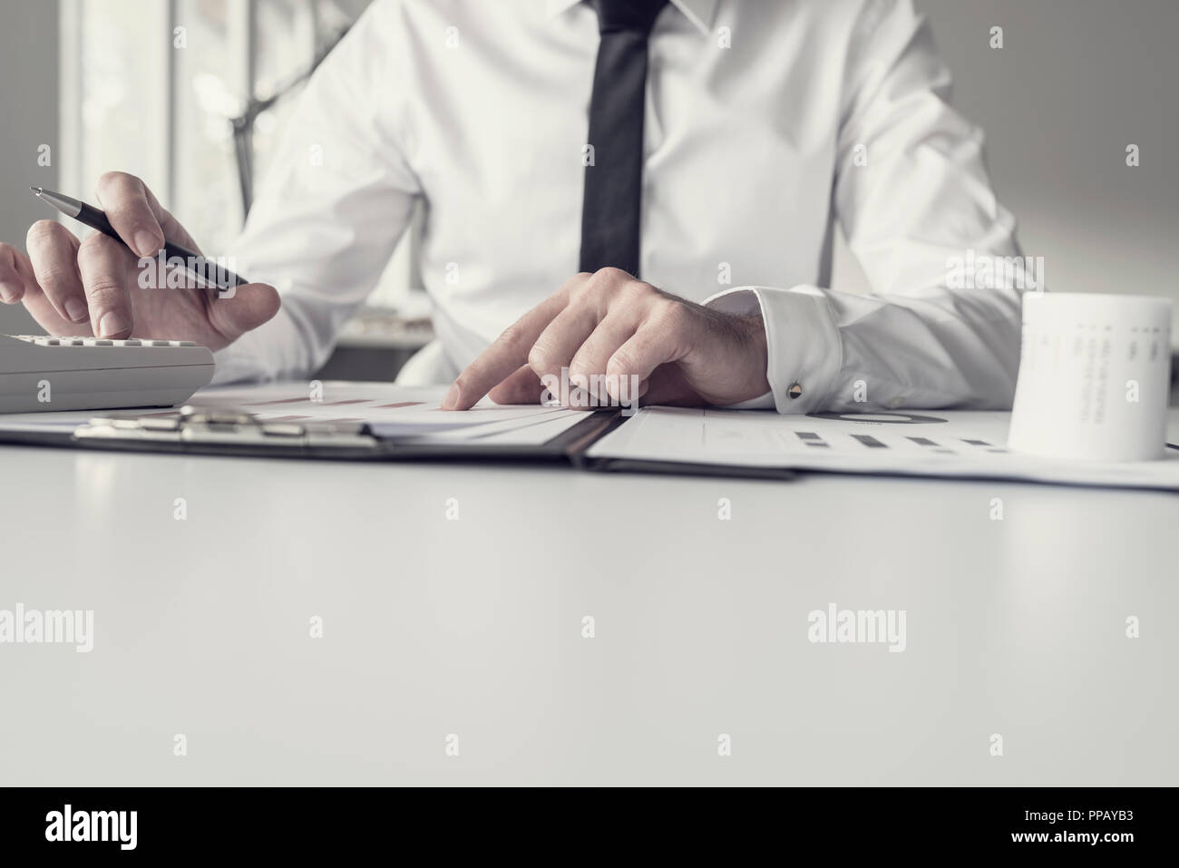 Retro toned image of business person checking facts on various printed ...