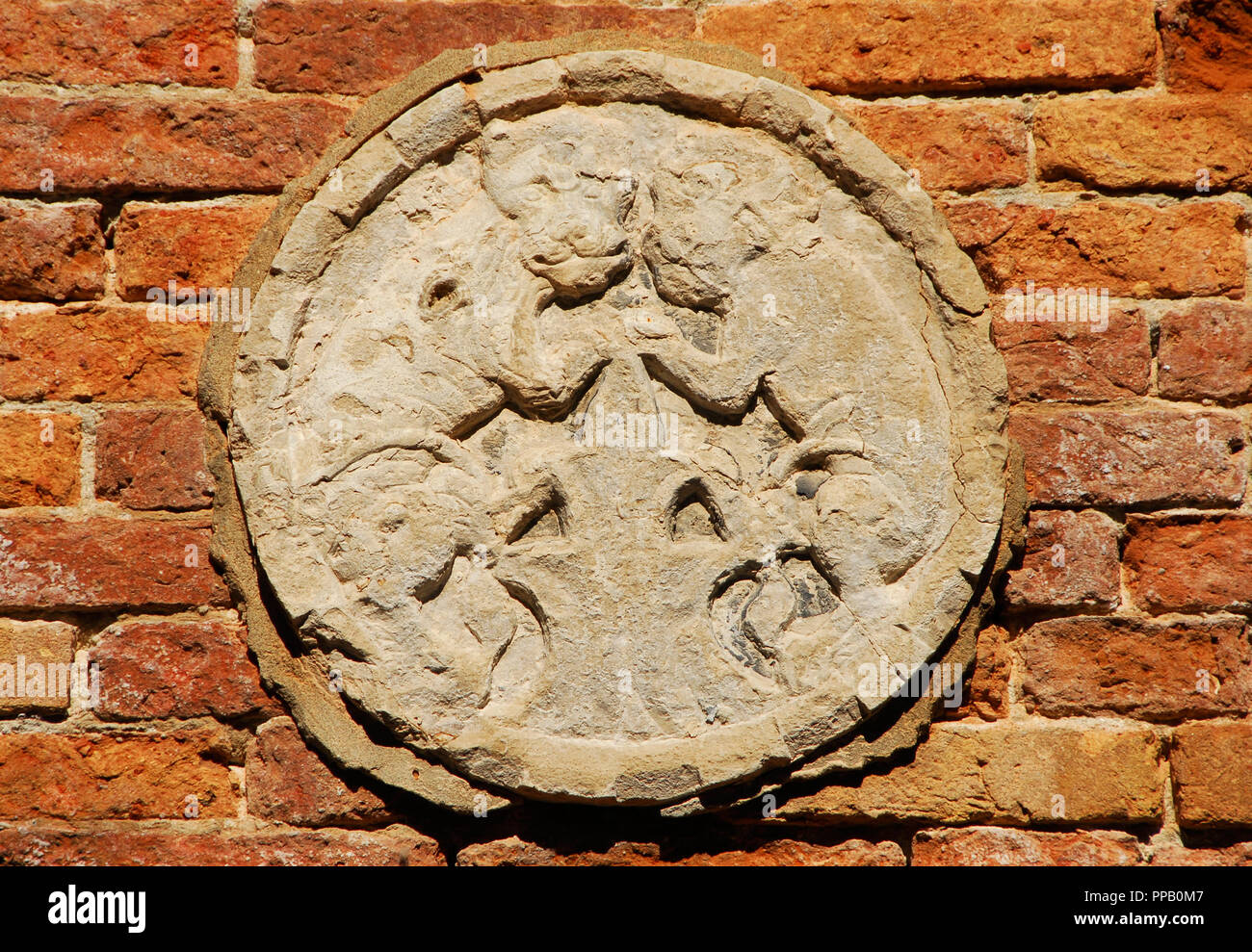 Ancient medieval round relief with two lions on a wall in Venice ...