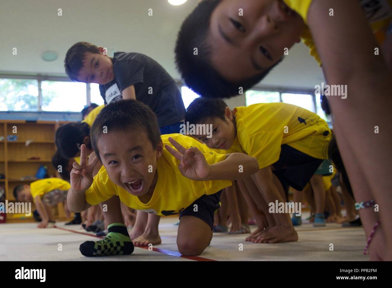 Okinawan children learn the English word “toes” during a community ...