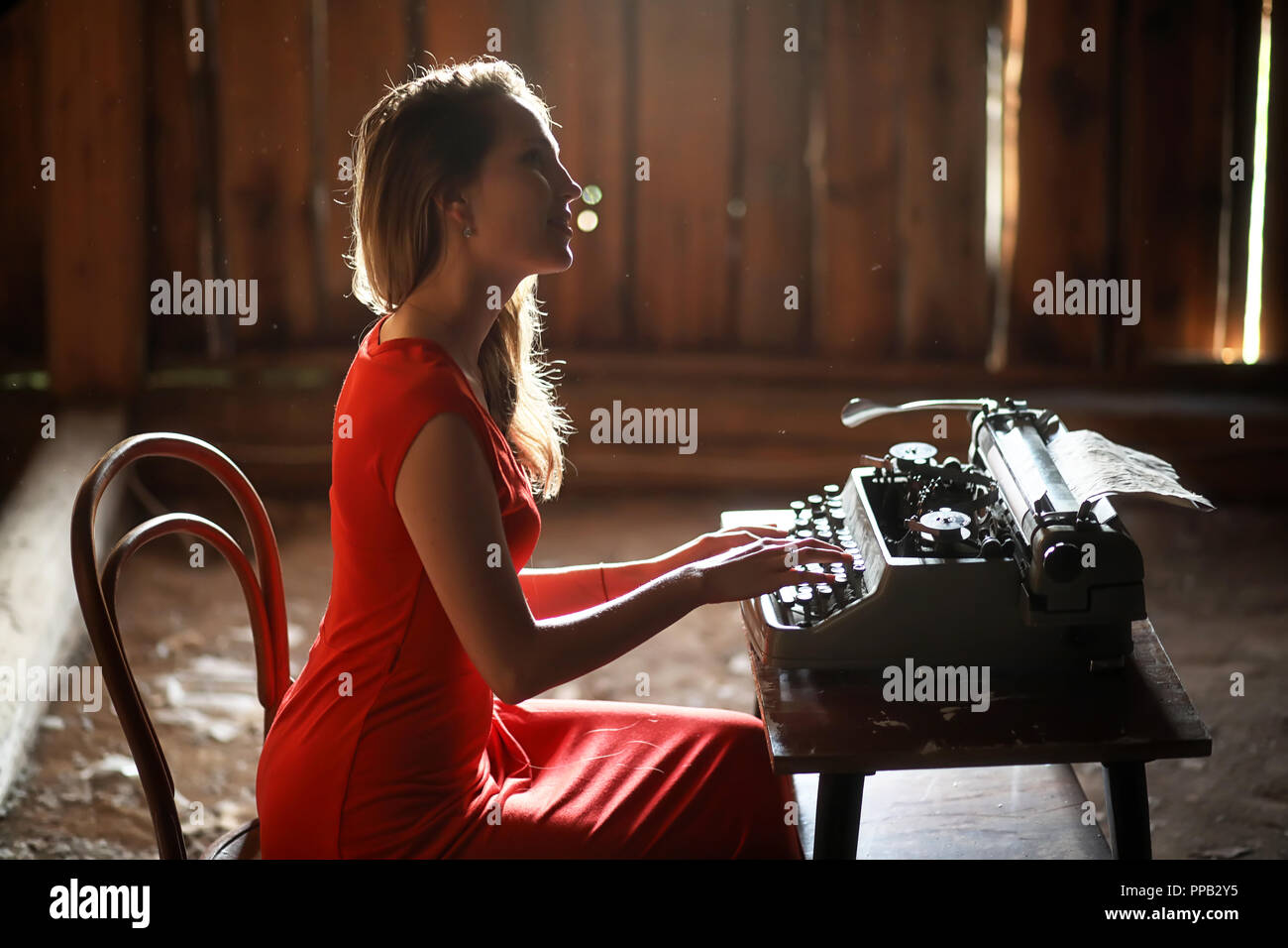 A girl in retro style prints on an old typewriter Stock Photo - Alamy