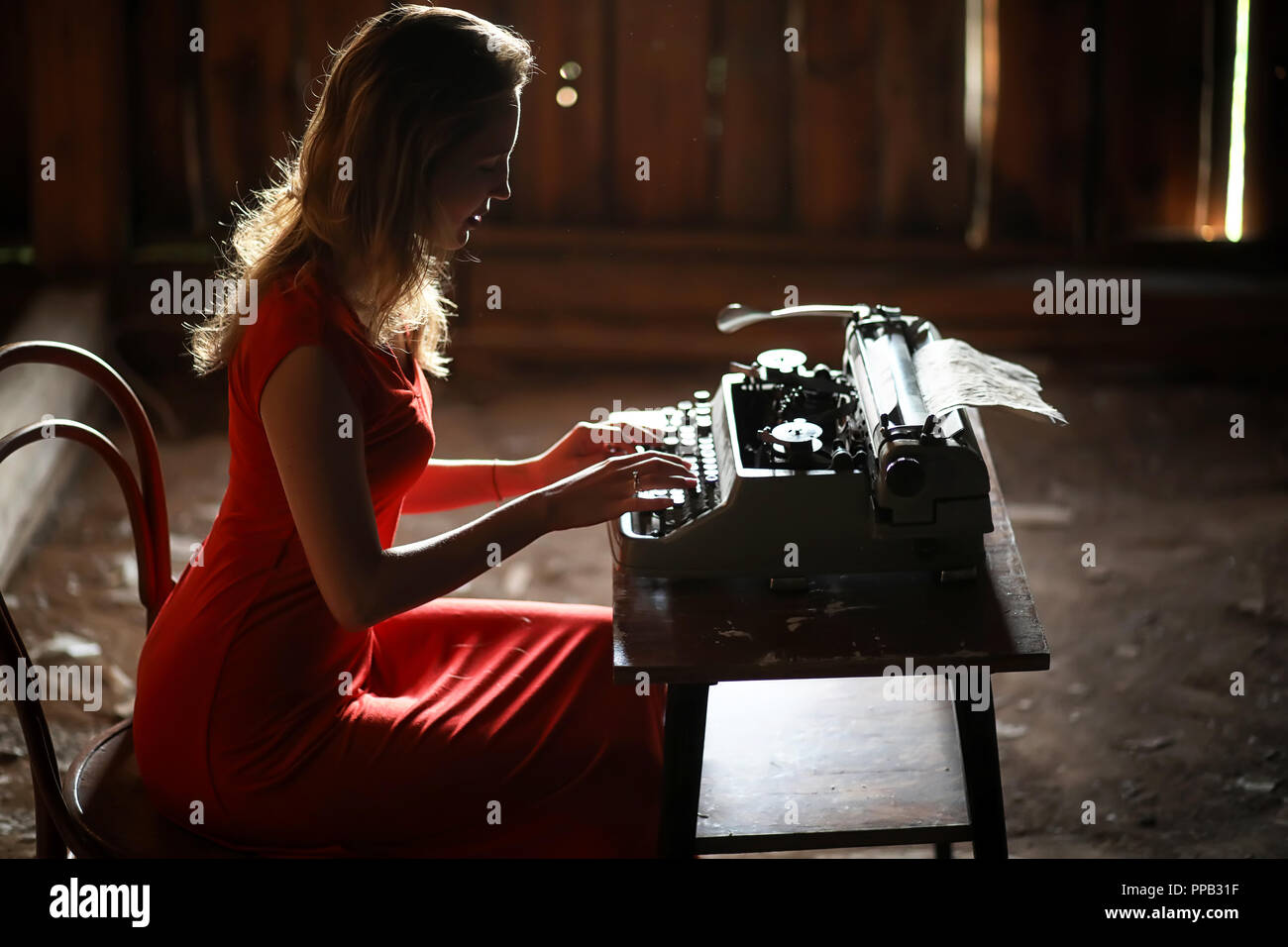 A girl in retro style prints on an old typewriter Stock Photo - Alamy
