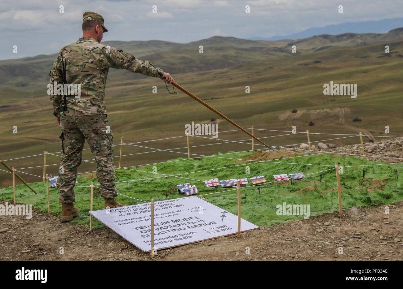 A Georgian army soldier demonstrates on a terrain model the location ...