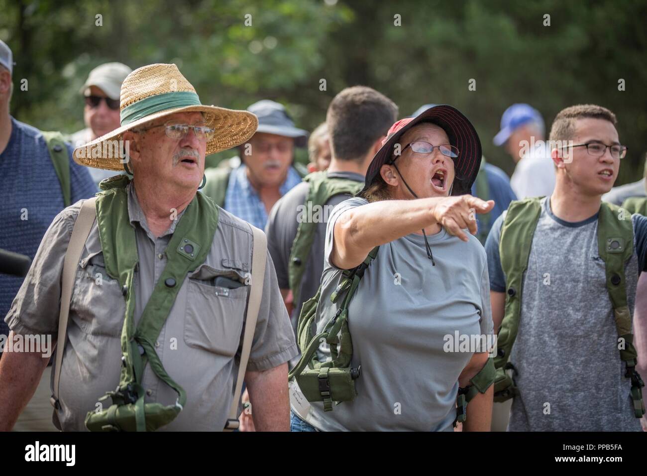 A group of civilian role players acting as an angry mob yell at ...