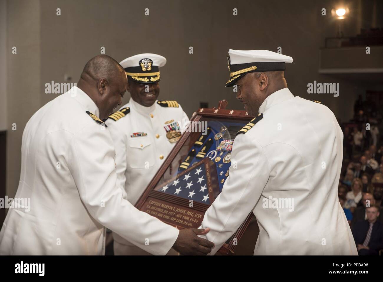 Capt. Marvin L. Jones (center) is presented with his shadow box during ...