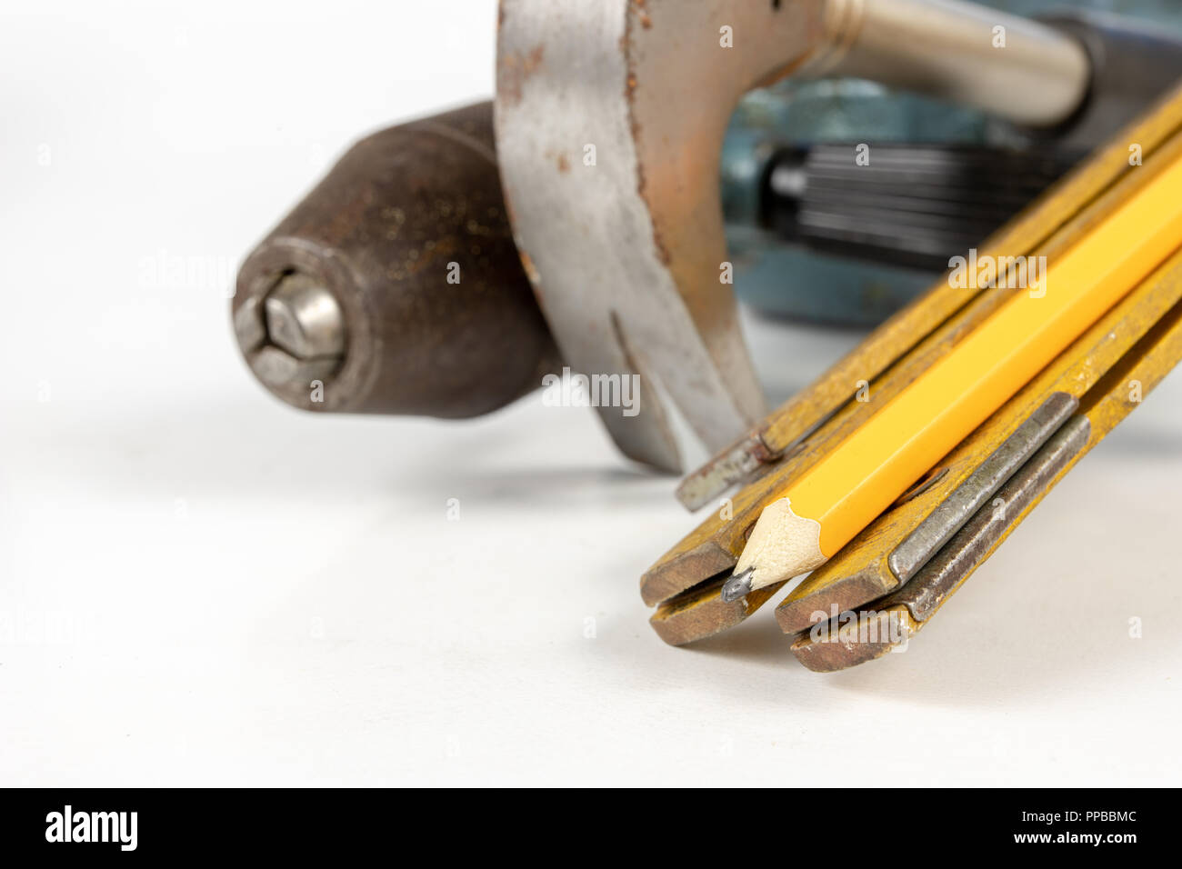 Measure and pencil on a white workshop table. Tools in a carpentry ...