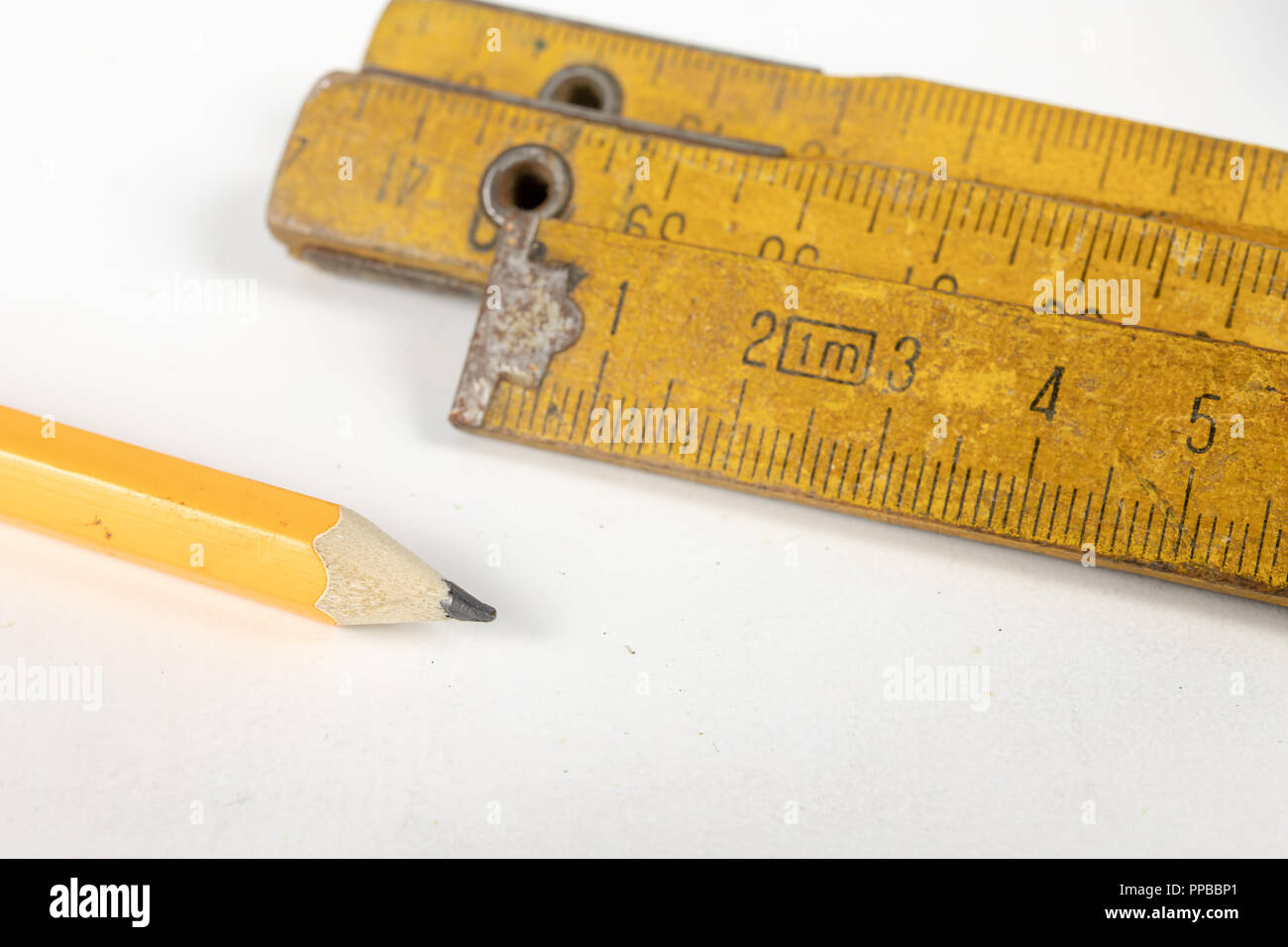 Measure and pencil on a white workshop table. Tools in a carpentry ...