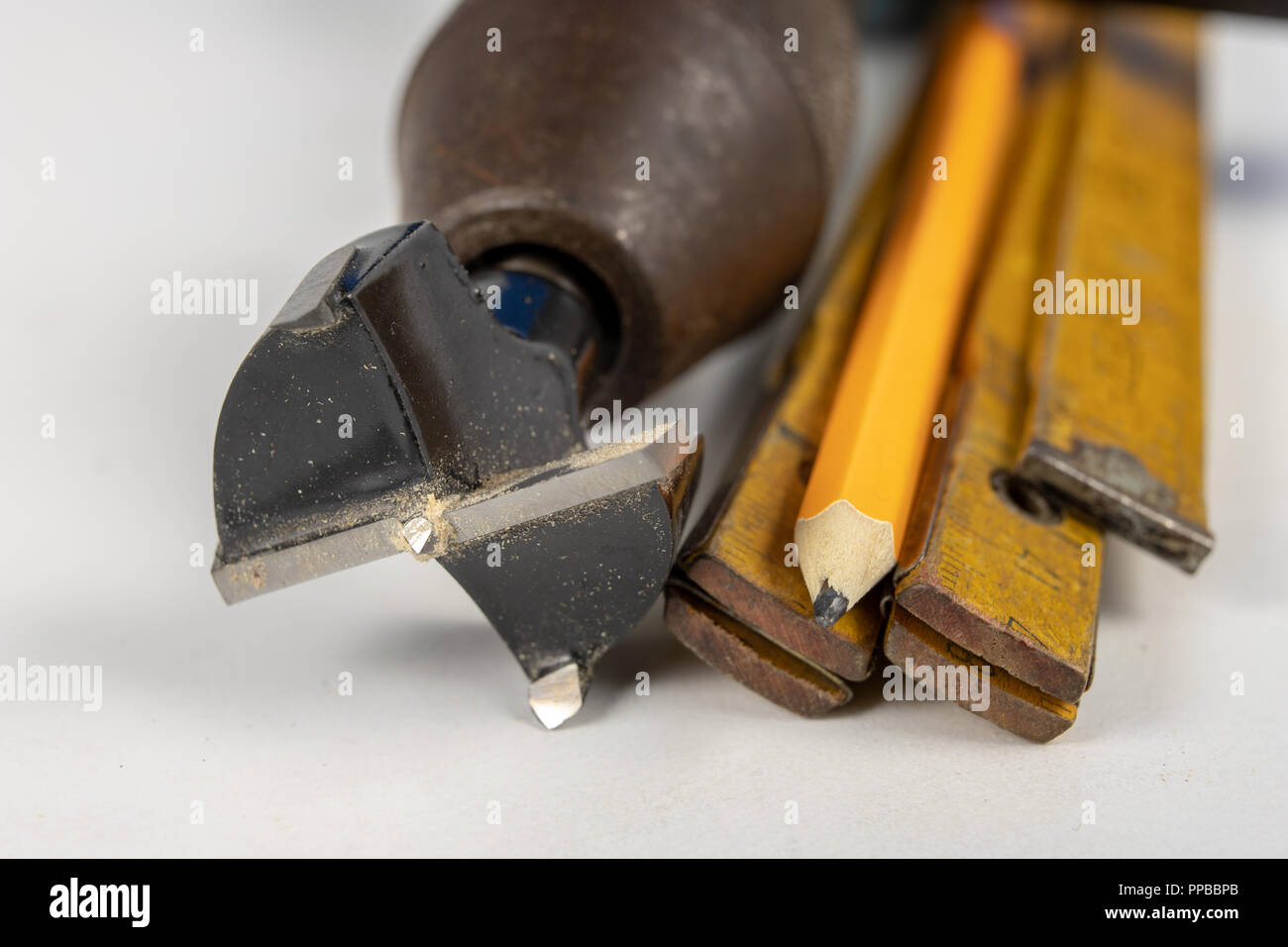 Measure and pencil on a white workshop table. Tools in a carpentry ...