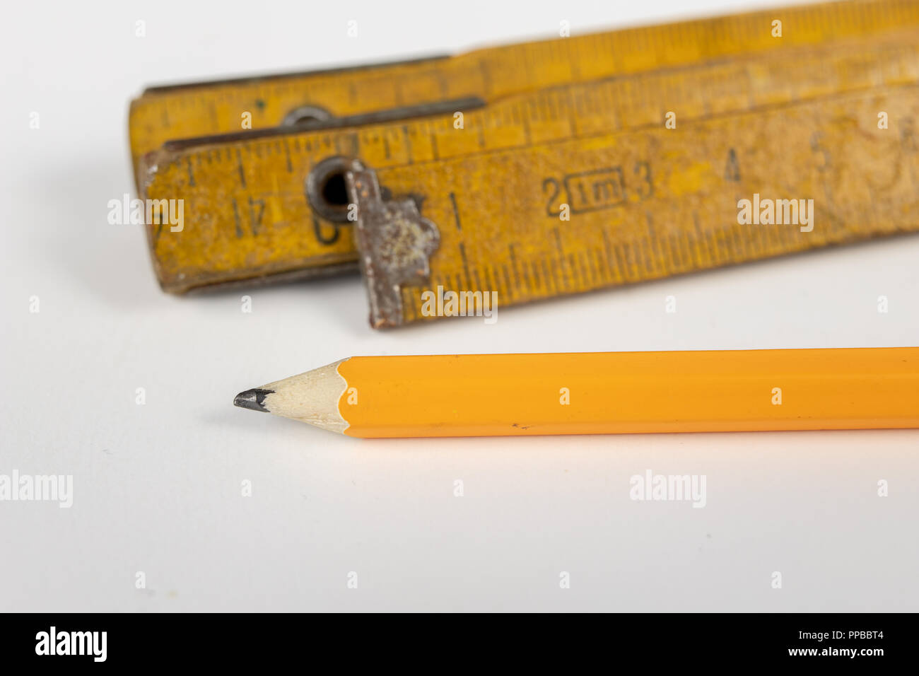 Measure and pencil on a white workshop table. Tools in a carpentry ...