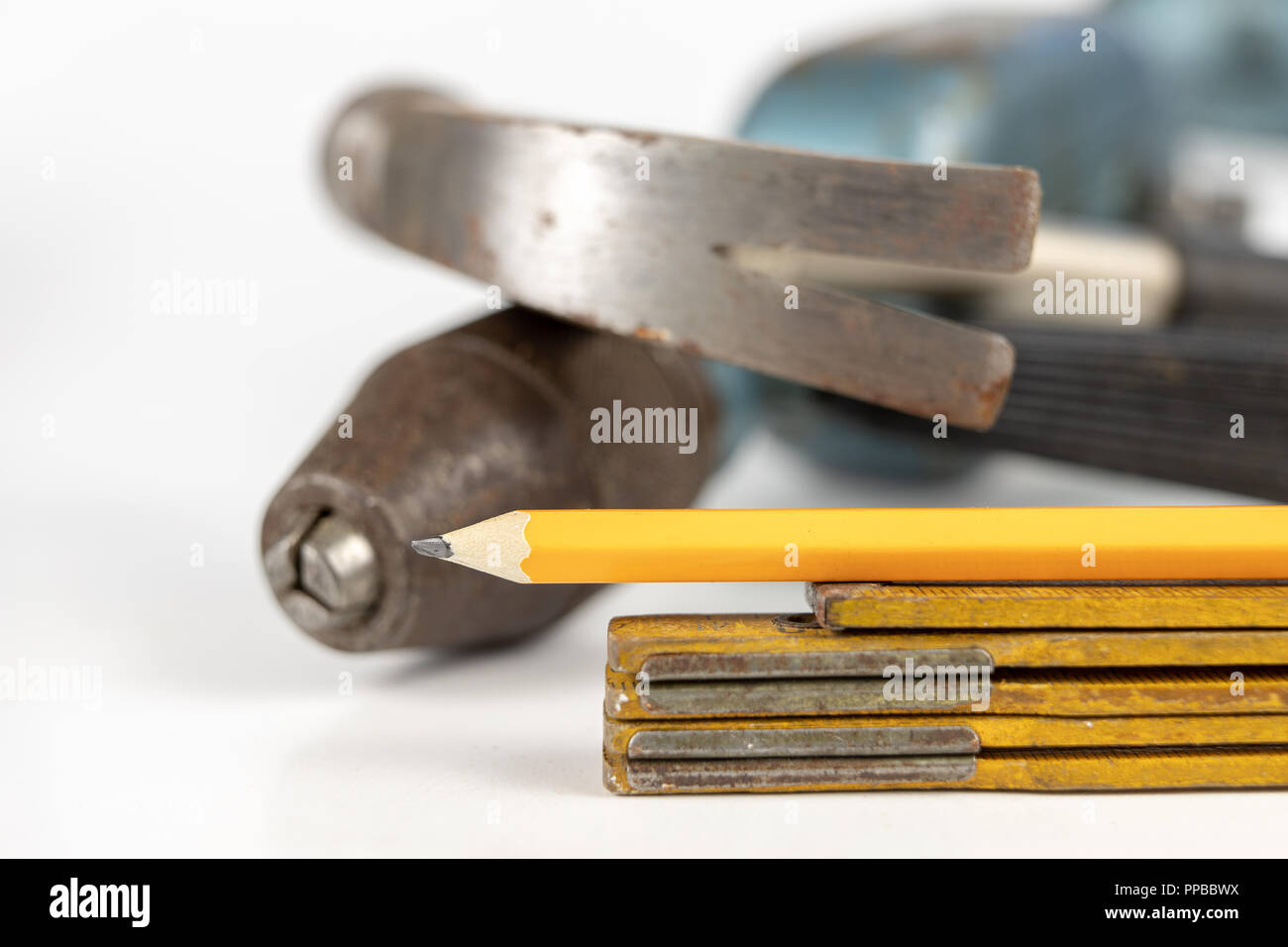 Measure and pencil on a white workshop table. Tools in a carpentry ...