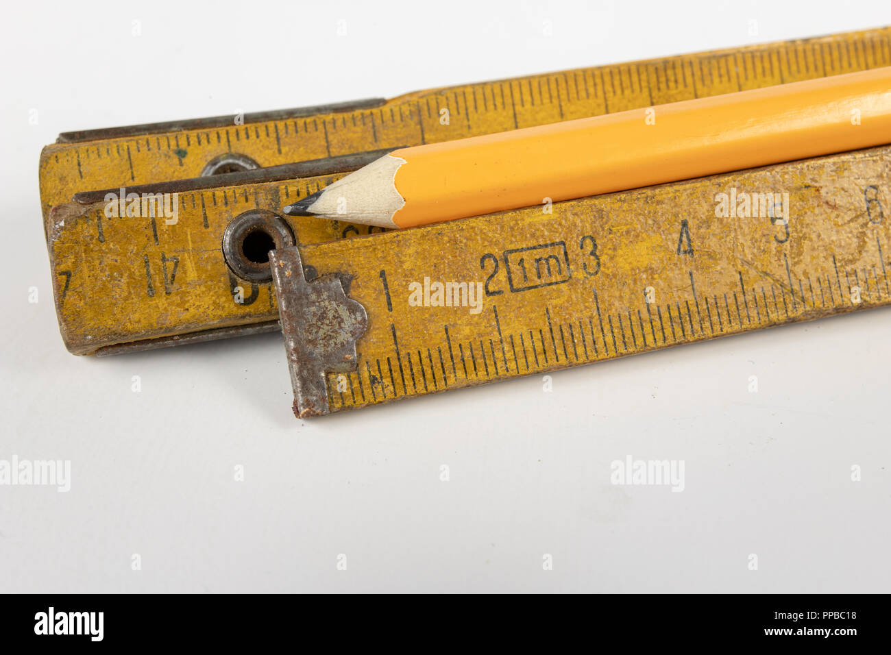Measure and pencil on a white workshop table. Tools in a carpentry ...