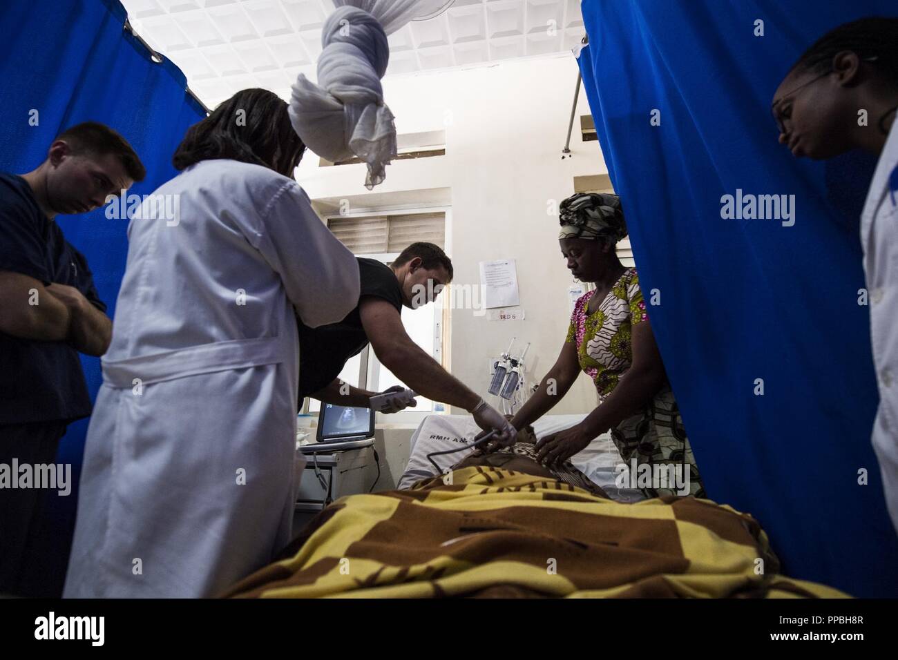 U.S. Army MAJ Thomas Nessler, center, emergency physician and ...