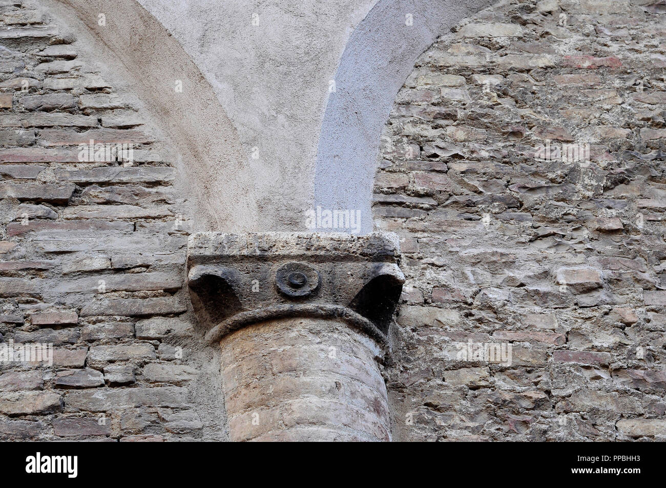 Stones and carved stone architectural details in wall of ancient ...