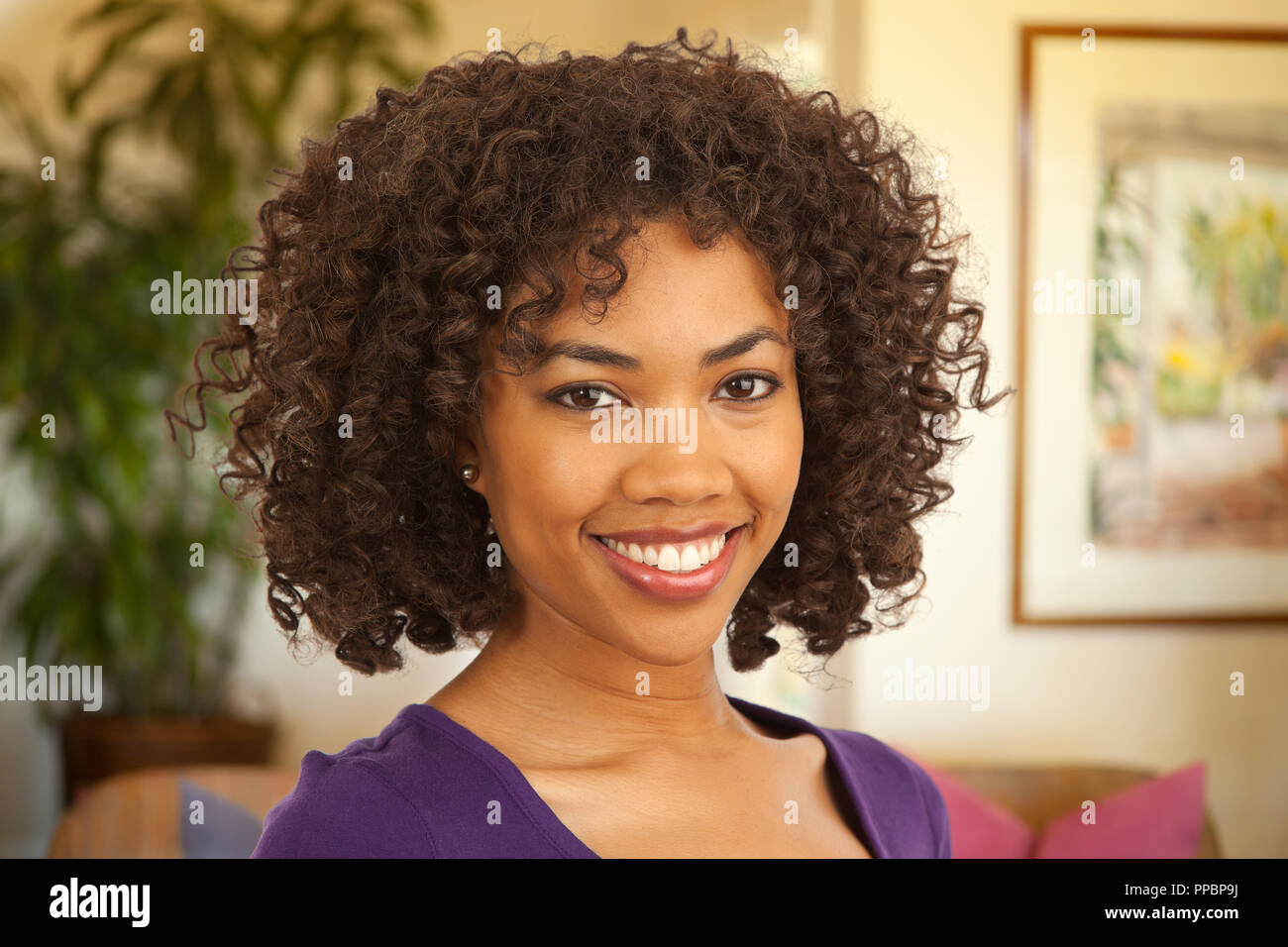 Close up portrait of millennial black woman smiling at camera at home ...