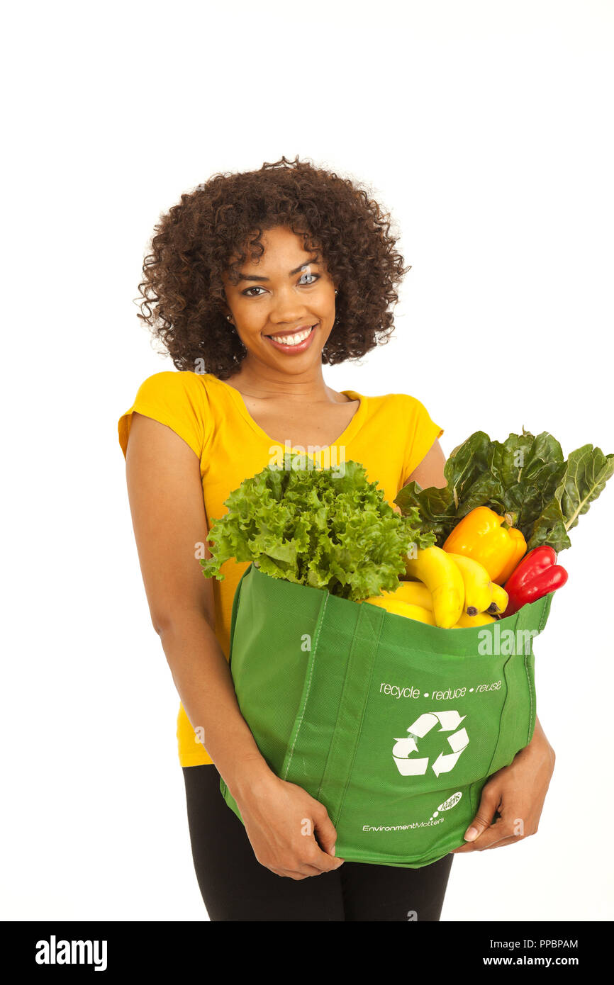 Beautiful young African woman carrying healthy groceries isolated on ...