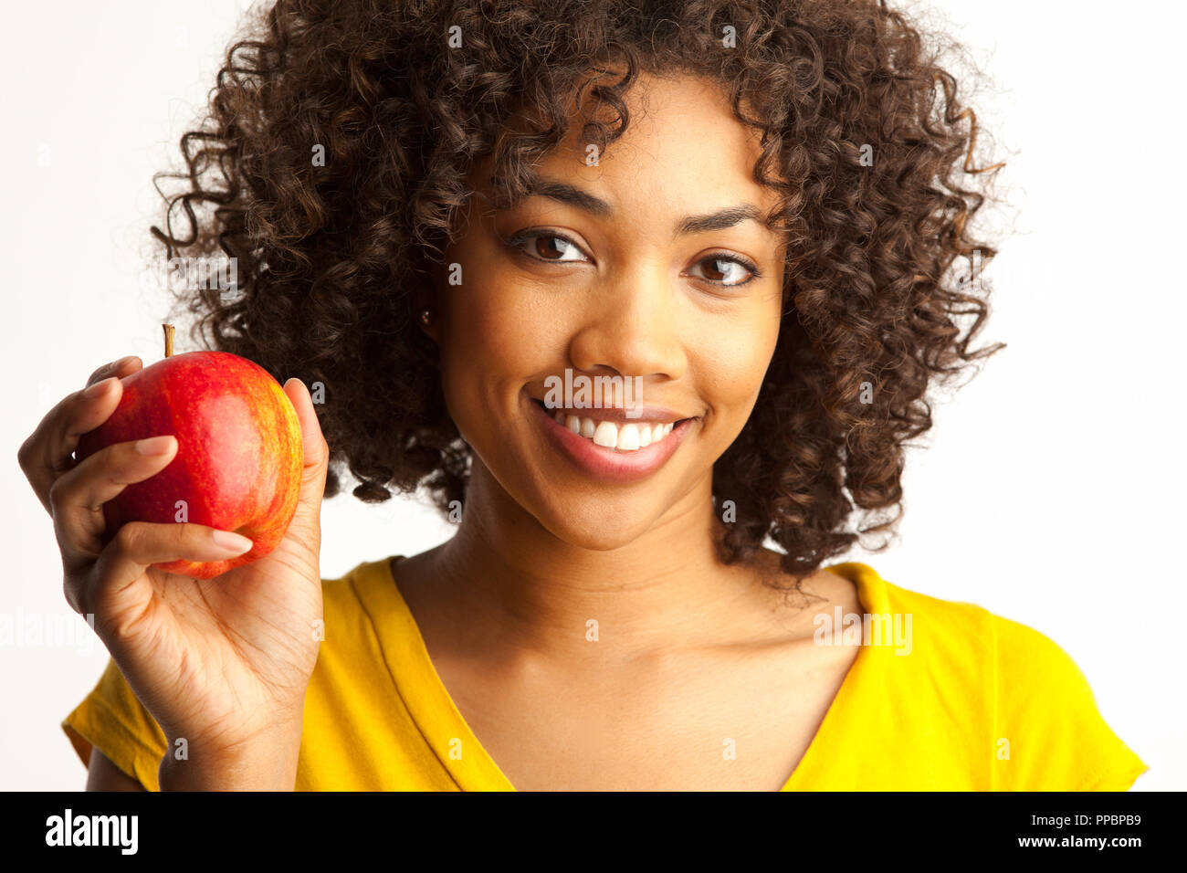 Close up of young African woman smilling and holding apple Stock Photo ...