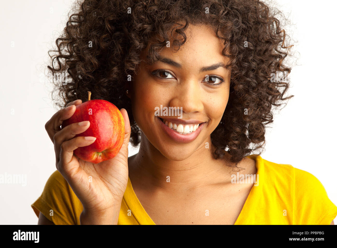 Close up of young African woman smilling and holding apple Stock Photo ...
