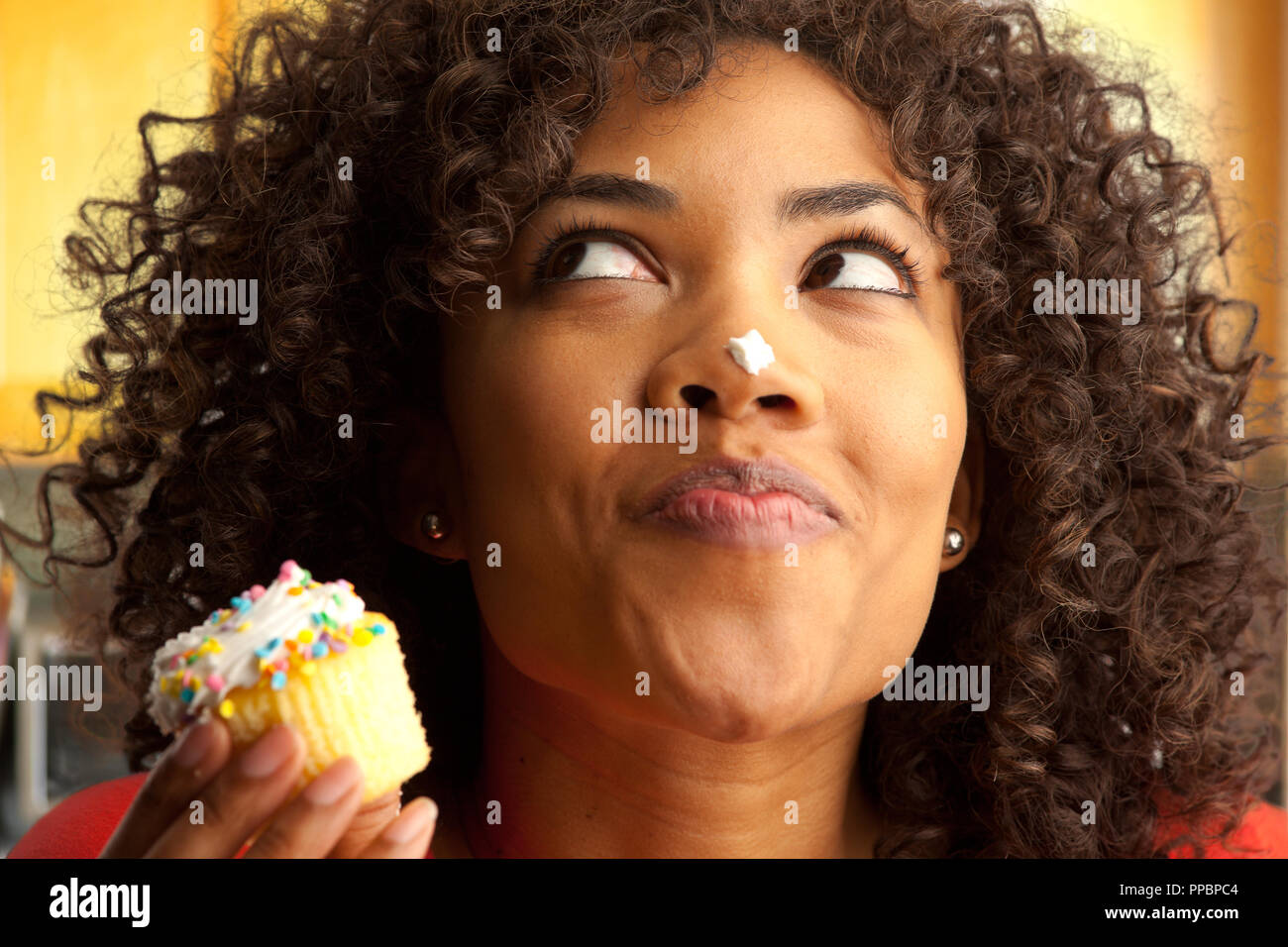 Portrait of young woman enjoying sweet cupcake Stock Photo - Alamy