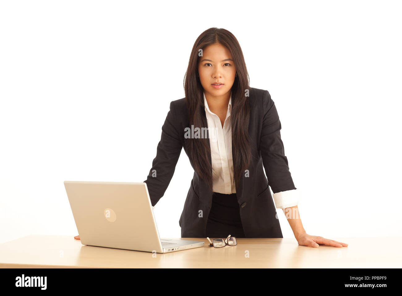 Attractive young business lady standing over desk with laptop computer ...