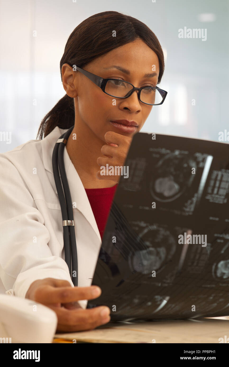 Portrait of female medical doctor reading x rays of patients brain ...