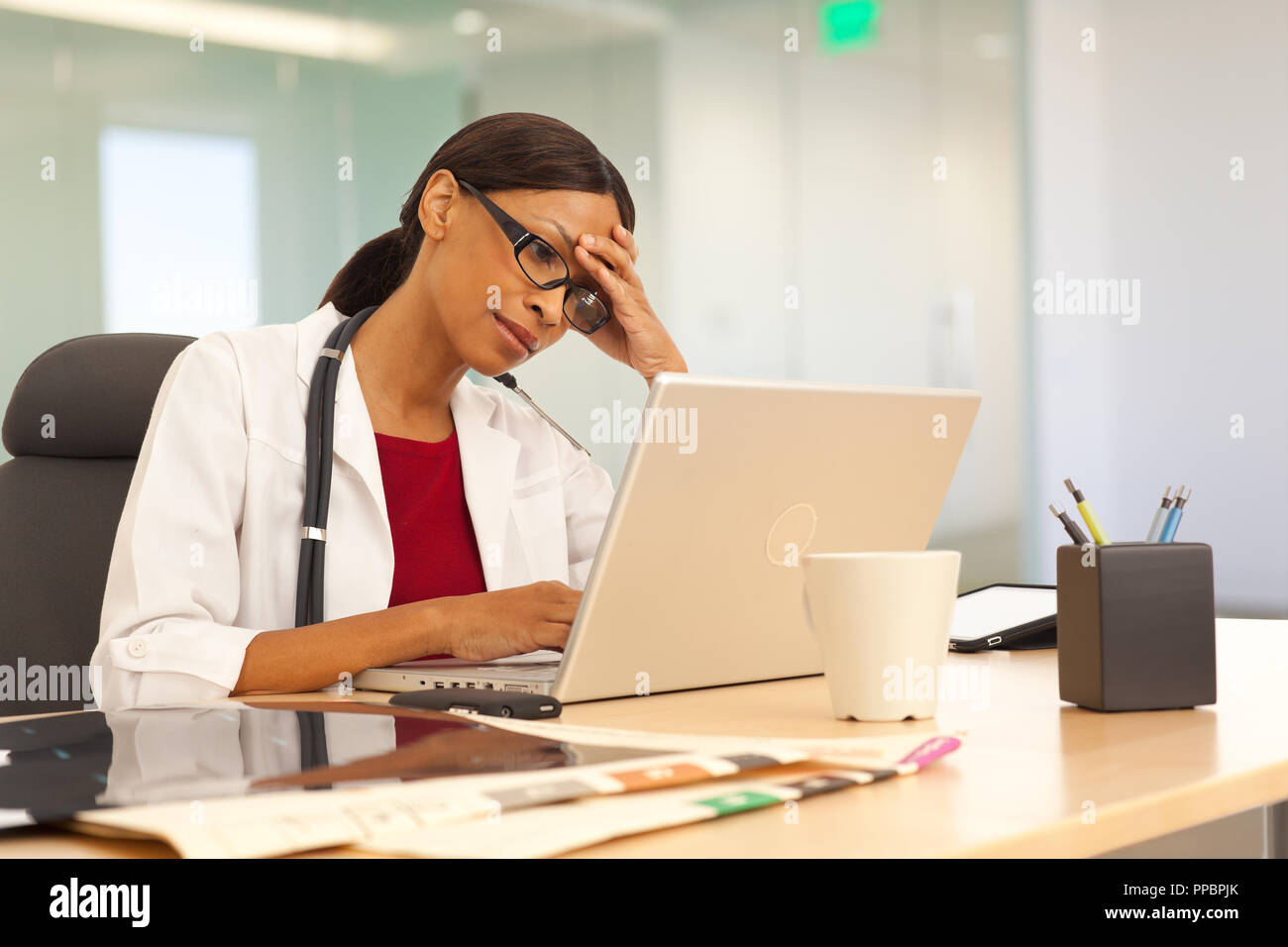 Stressed young female physician using laptop computer at work Stock ...