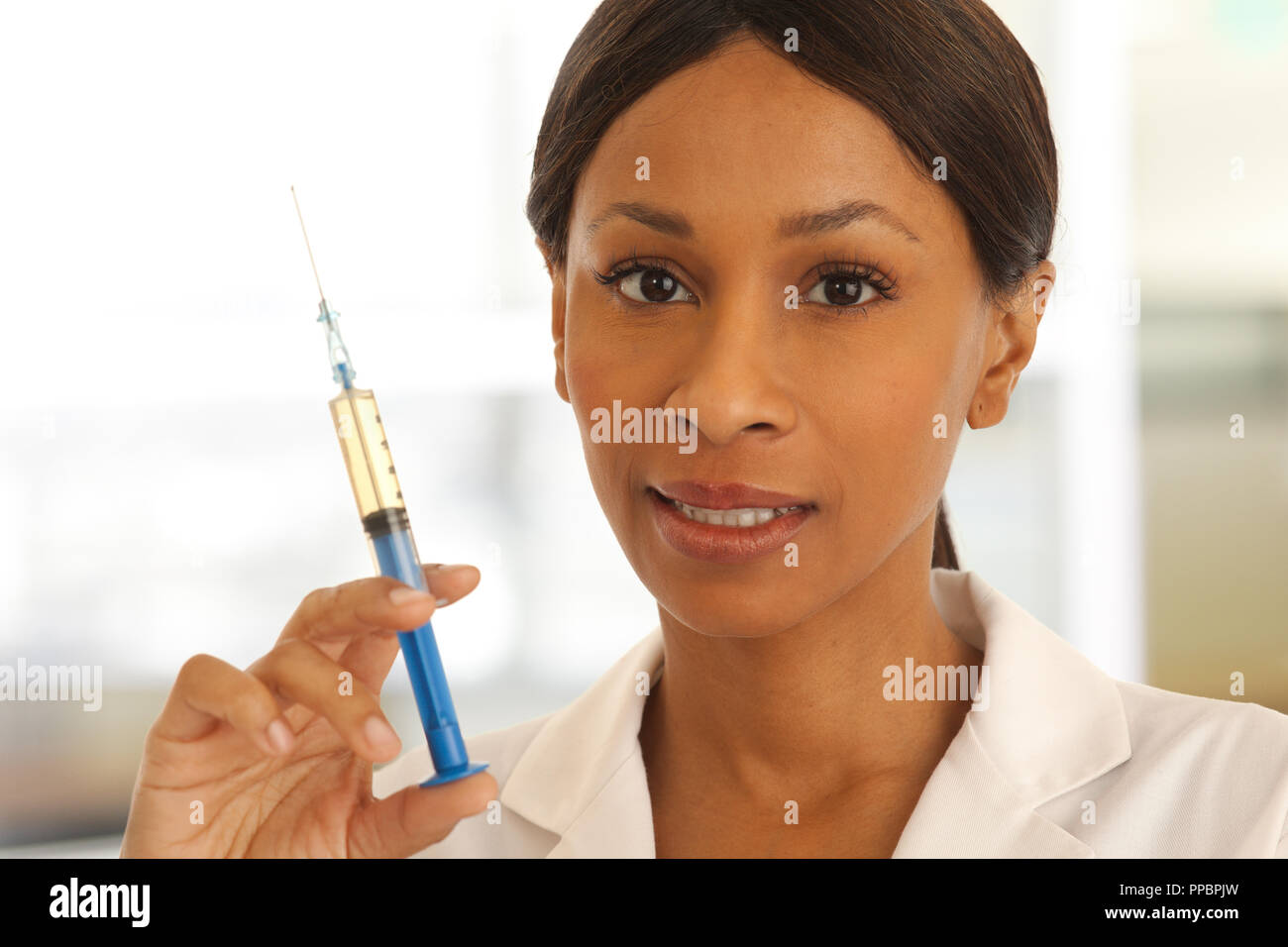 Closeup of young African doctor holding medical injection for ...
