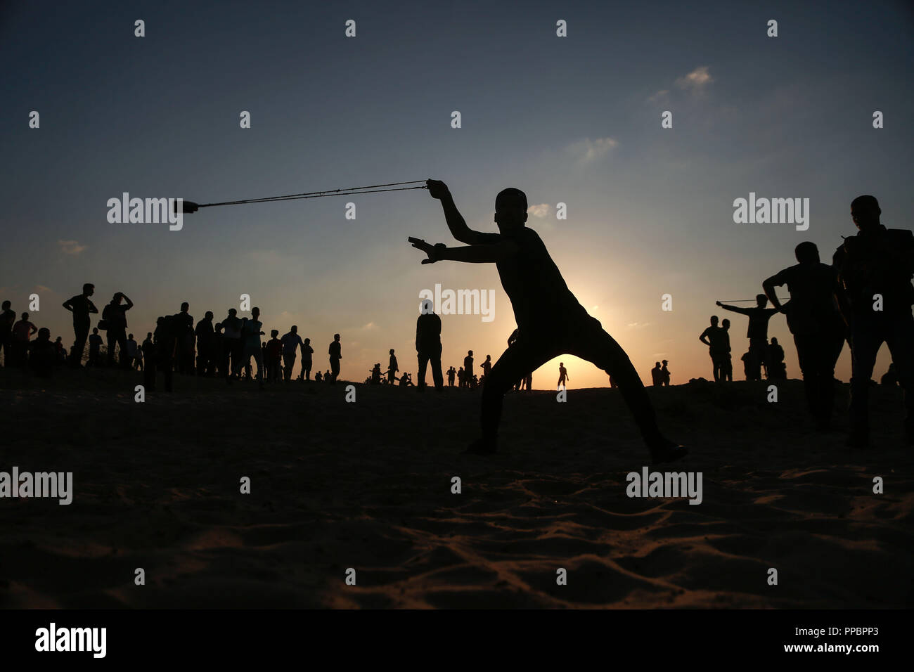Gaza. 24th Sep, 2018. A Palestinian protester uses a slingshot to hurl ...