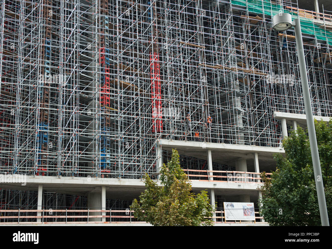 Feature - View of construction workers standing on the scaffolding of ...