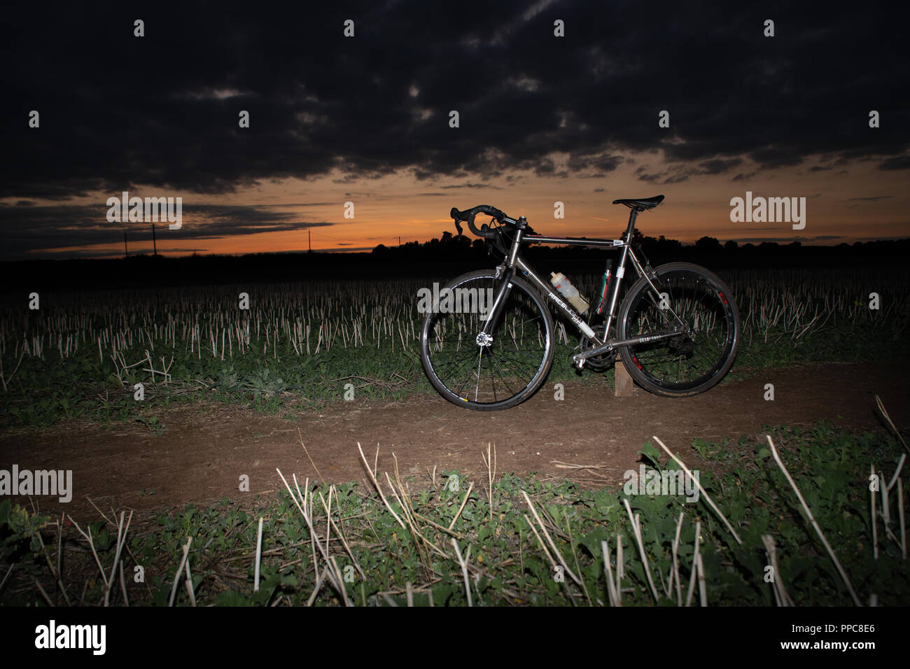 Bicycle road bike with sunset backgound Stock Photo - Alamy