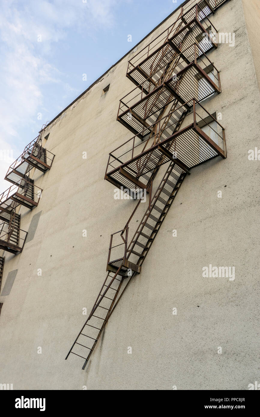 Rusted fire ladder on old house with blue sky and white clouds Stock ...