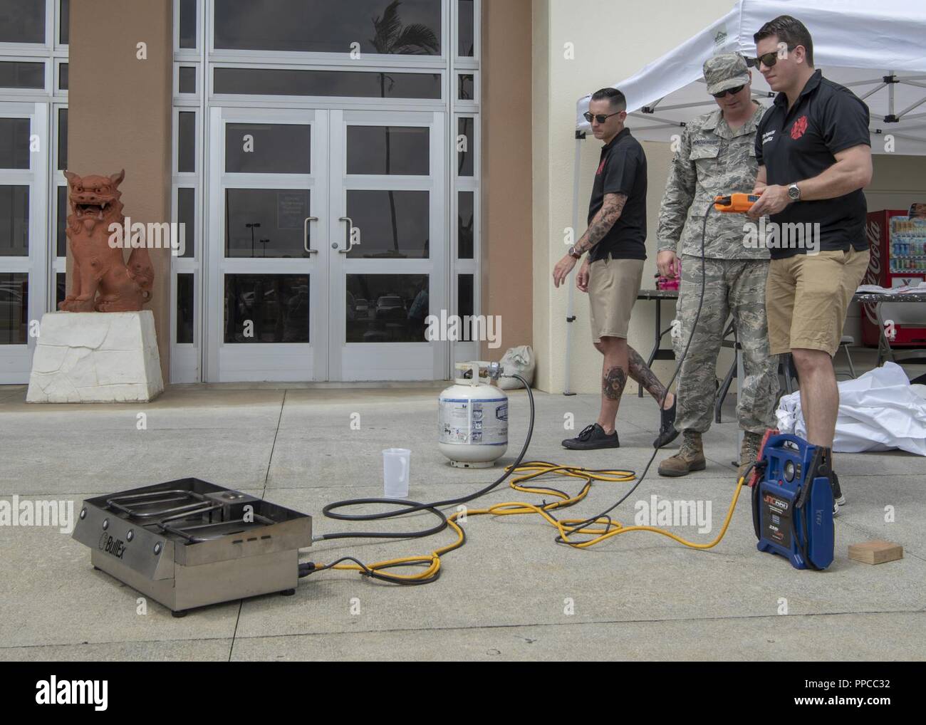 Members from the Kadena Fire Department hook up a fire system during a ...