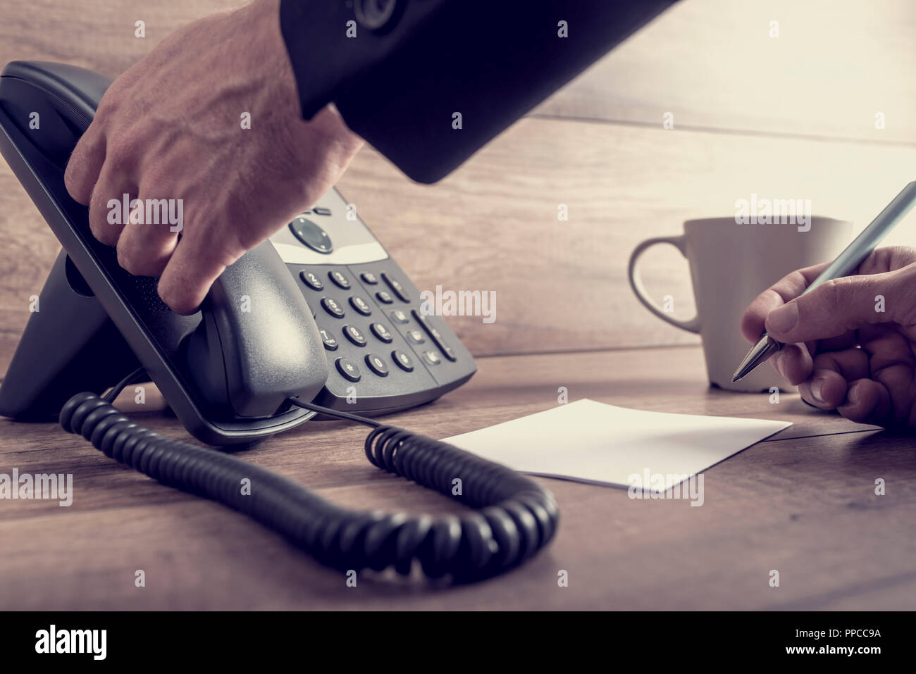 Closeup of male assistant about to answer a telephone call on black ...