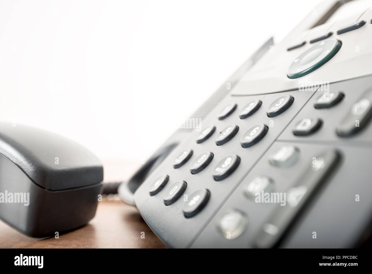 Close up angled view of a black landline telephone with a number pad ...