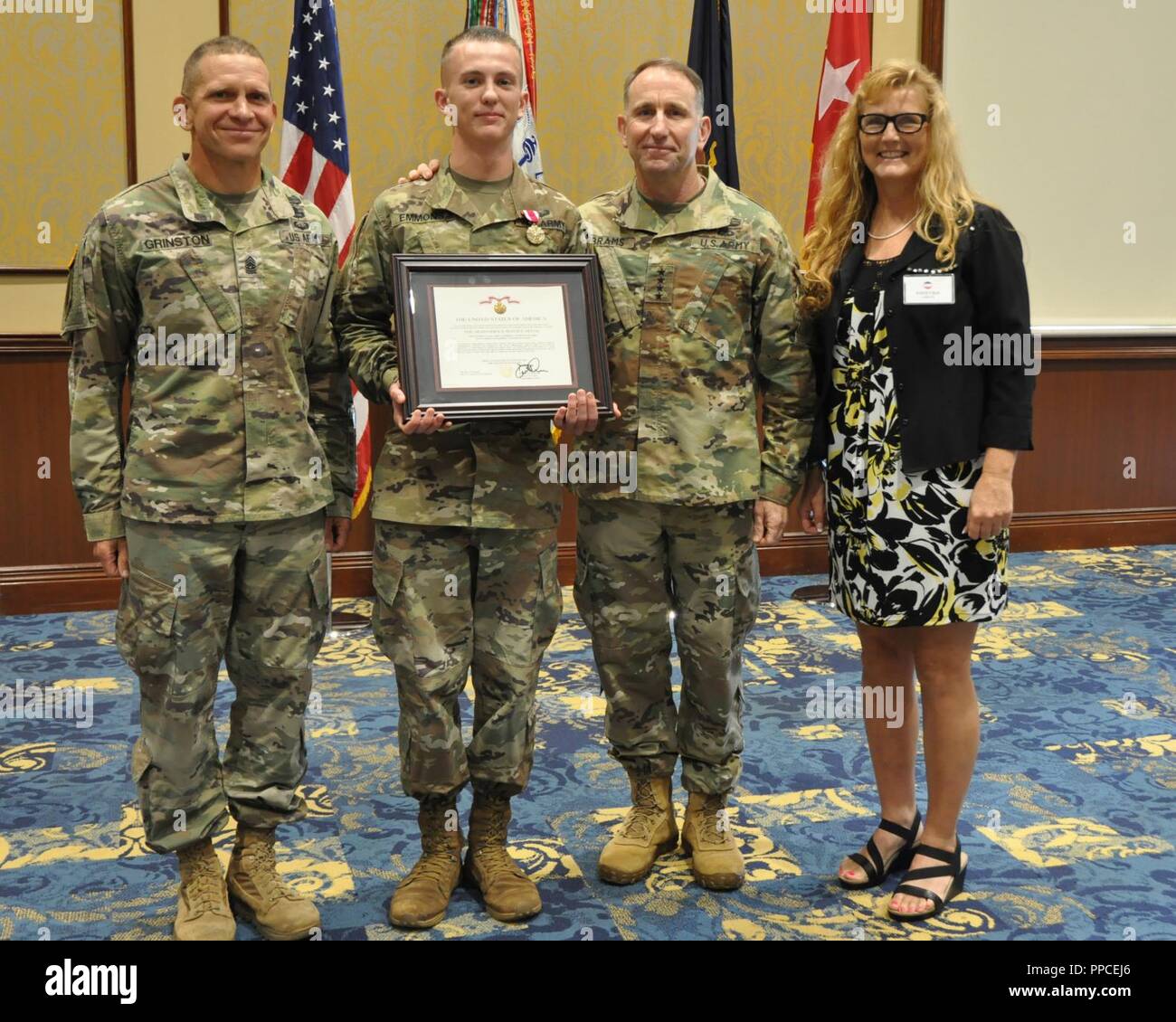 Pfc. Caden J. Emmons, center, receives the Meritorious Service Medal ...