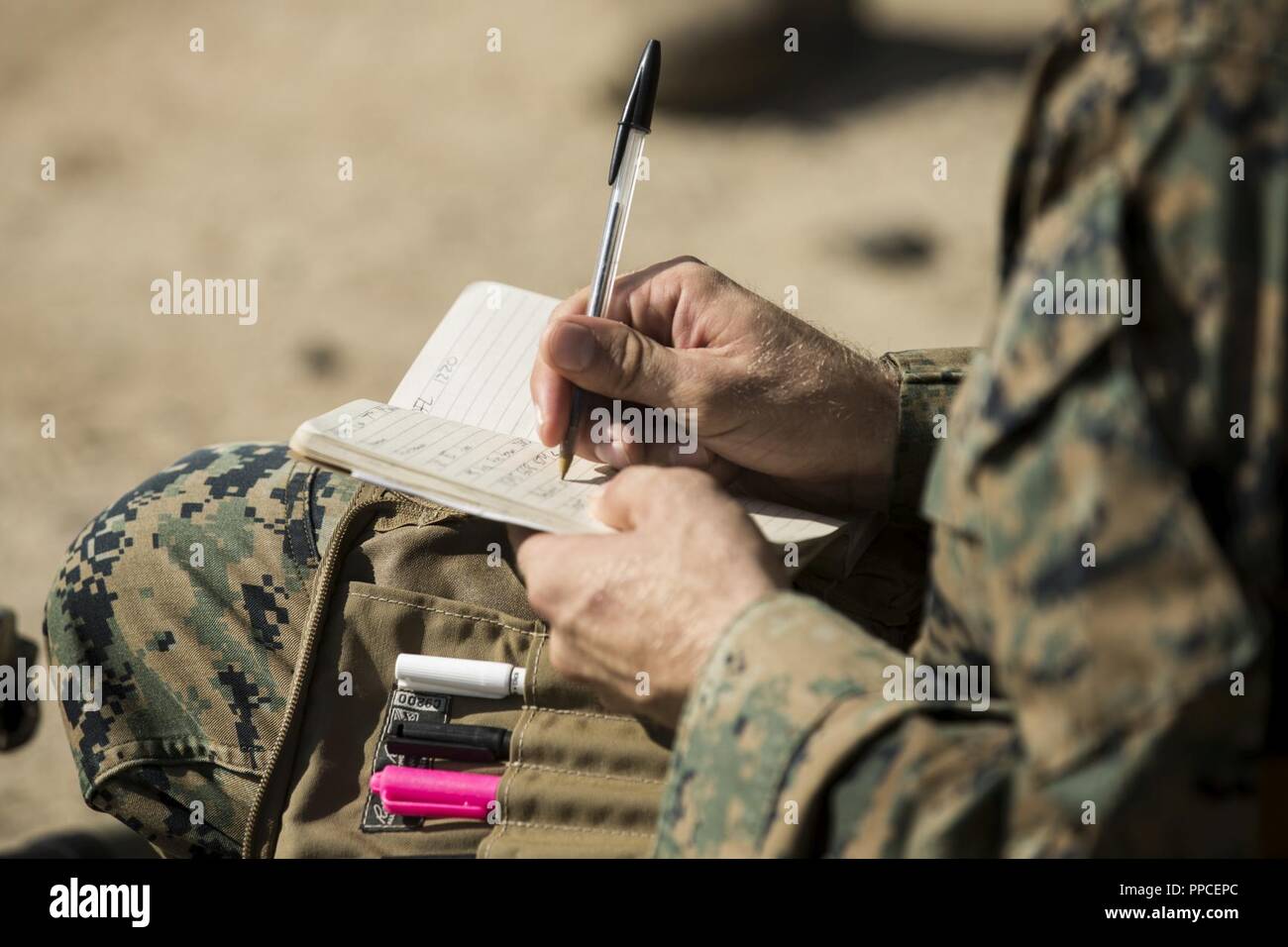 A U.S. Marine with 2nd Battalion, 7th Marine Regiment, writes notes ...