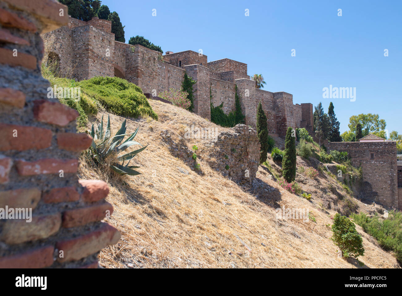 Fortifications of Malaga moorish Citadel. Surrounded by green plants ...
