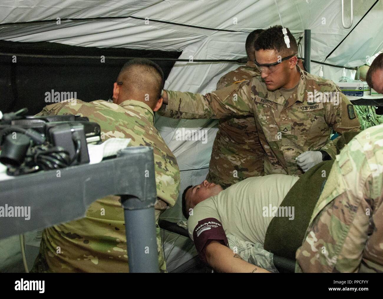 Soldiers with the 131st Field Hospital, 528th Hospital Center, assess a ...