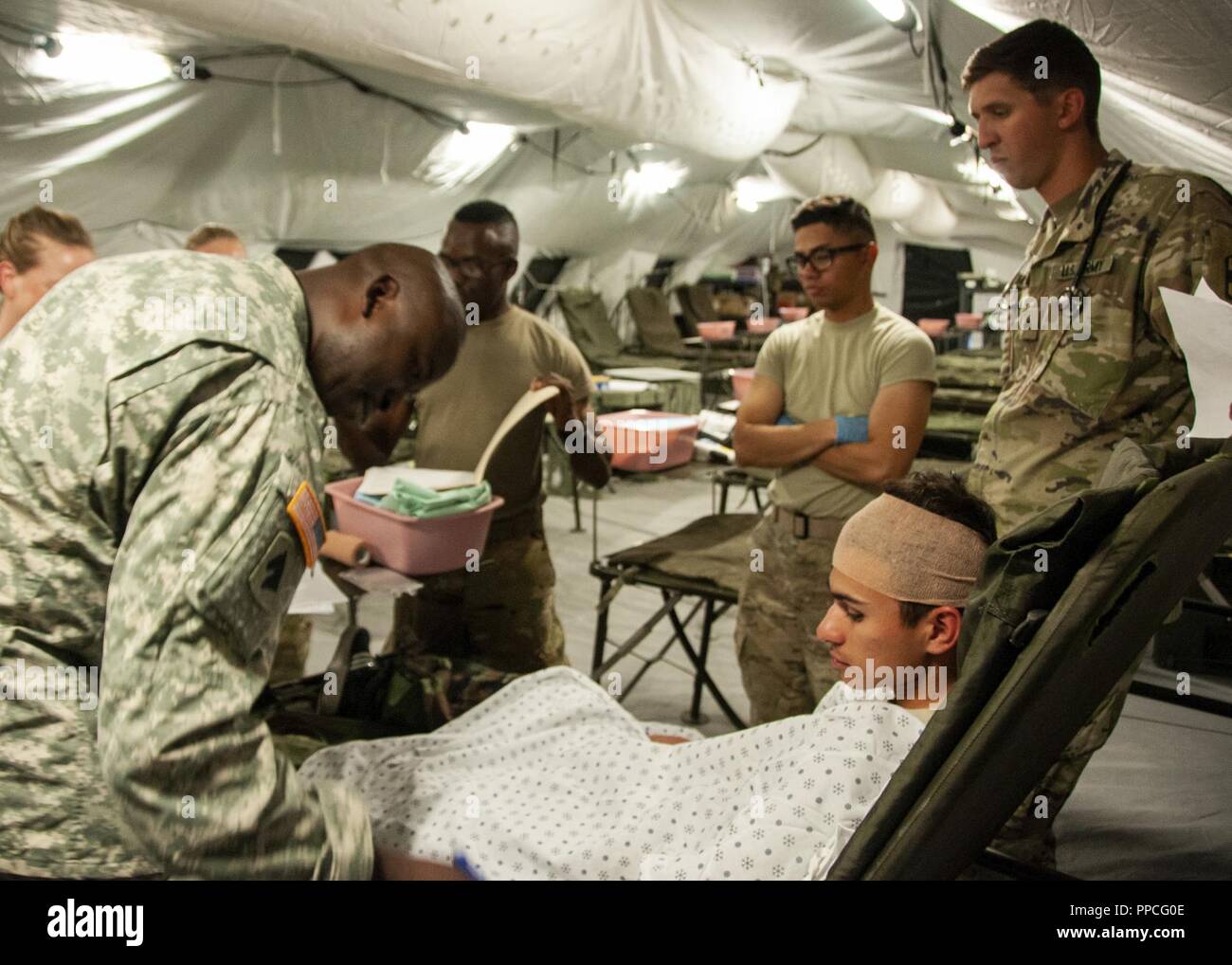 Soldiers with the 131st Field Hospital, 528th Hospital Center, assess a ...