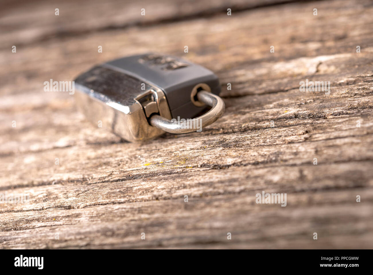 Security concept - metal padlock lying on old rustic cracked wooden ...